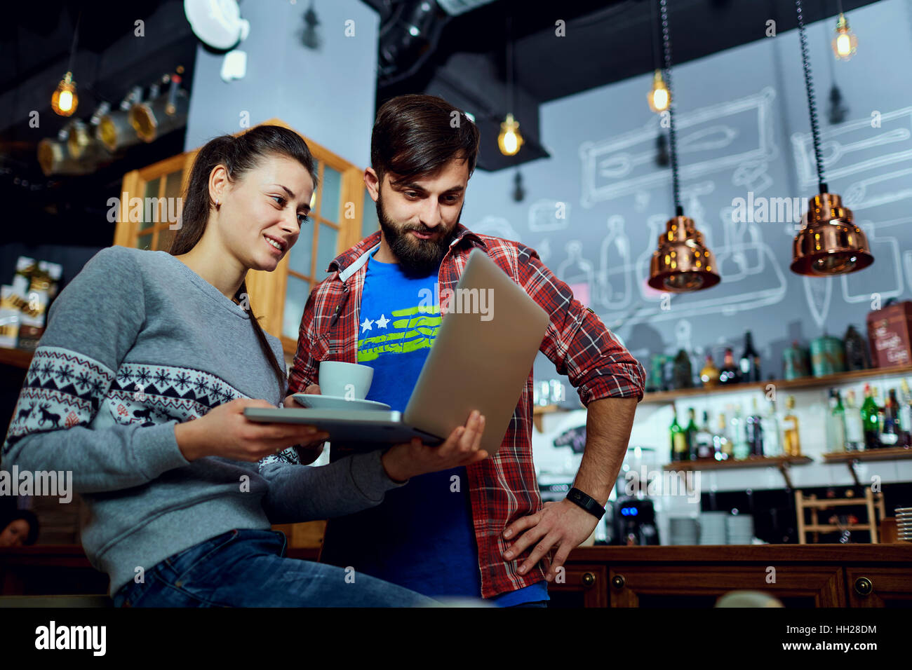 Young people at a cafe looking notebook. Couple with the laptop Stock ...