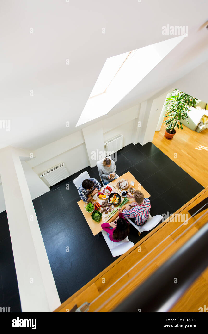 Group of young people have a dinner in modern kitchen Stock Photo - Alamy