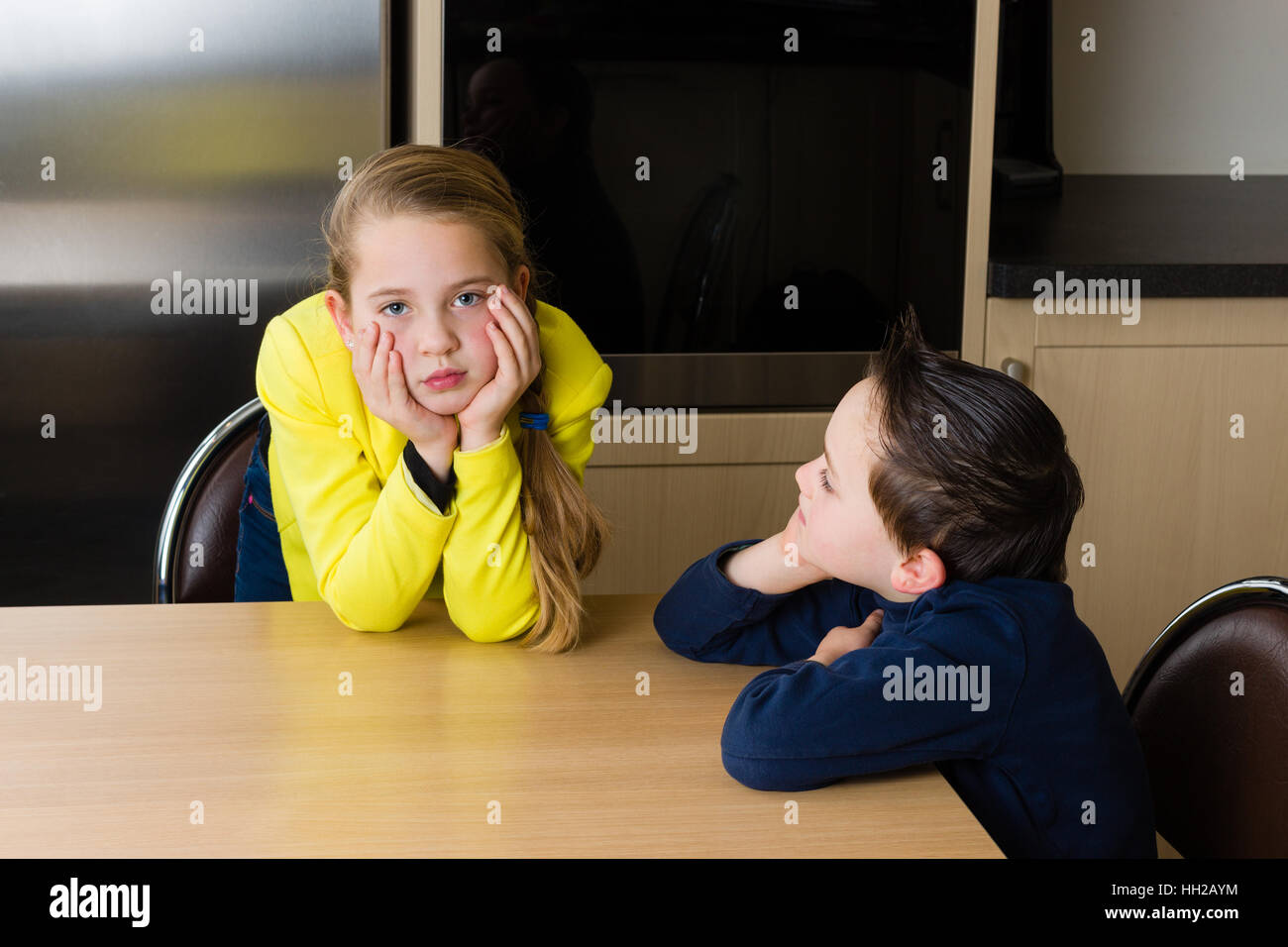 Kids (siblings boy and girl) are arguing at the kitchen table Stock ...