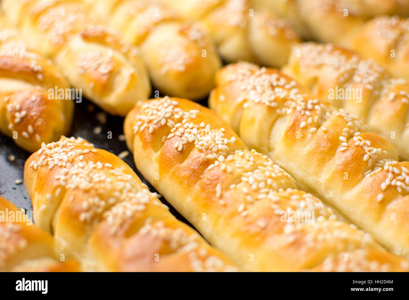 Homemade sesame pastry on black baking pan Stock Photo - Alamy