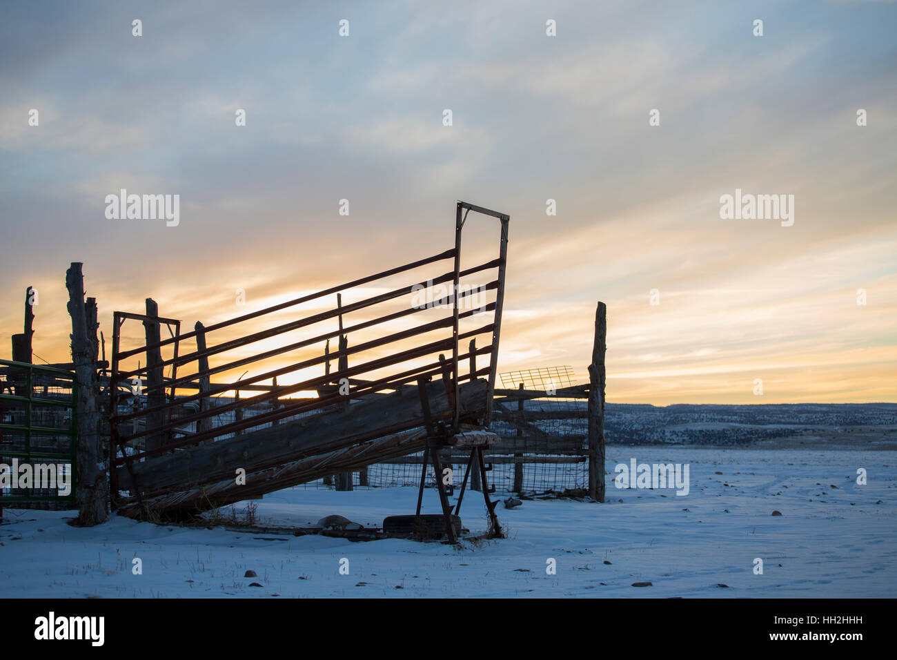 Livestock loading ramp and corral against a sunset in western Colorado ...