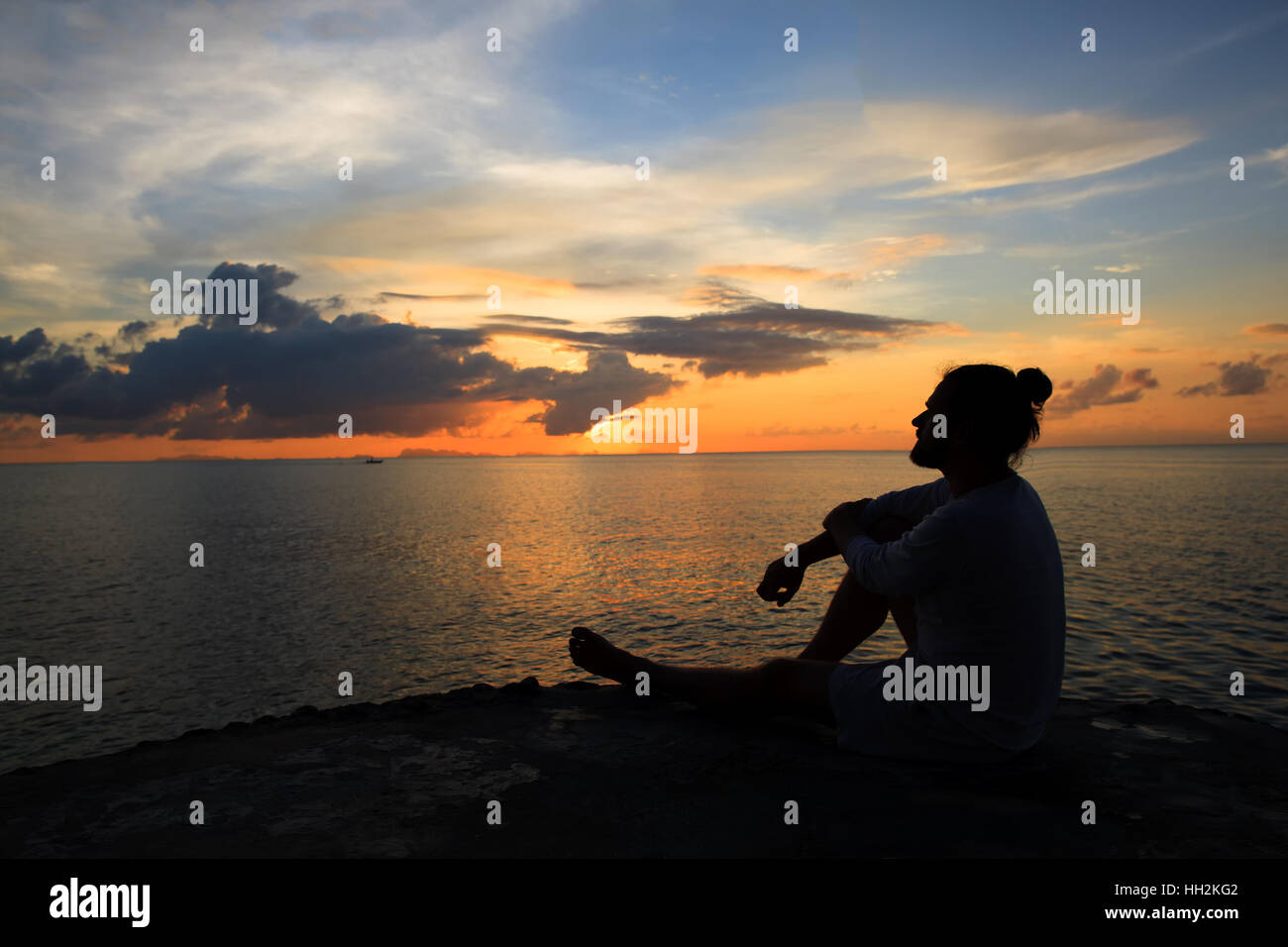 Yoga scene man silhouette in sunset background Stock Photo - Alamy