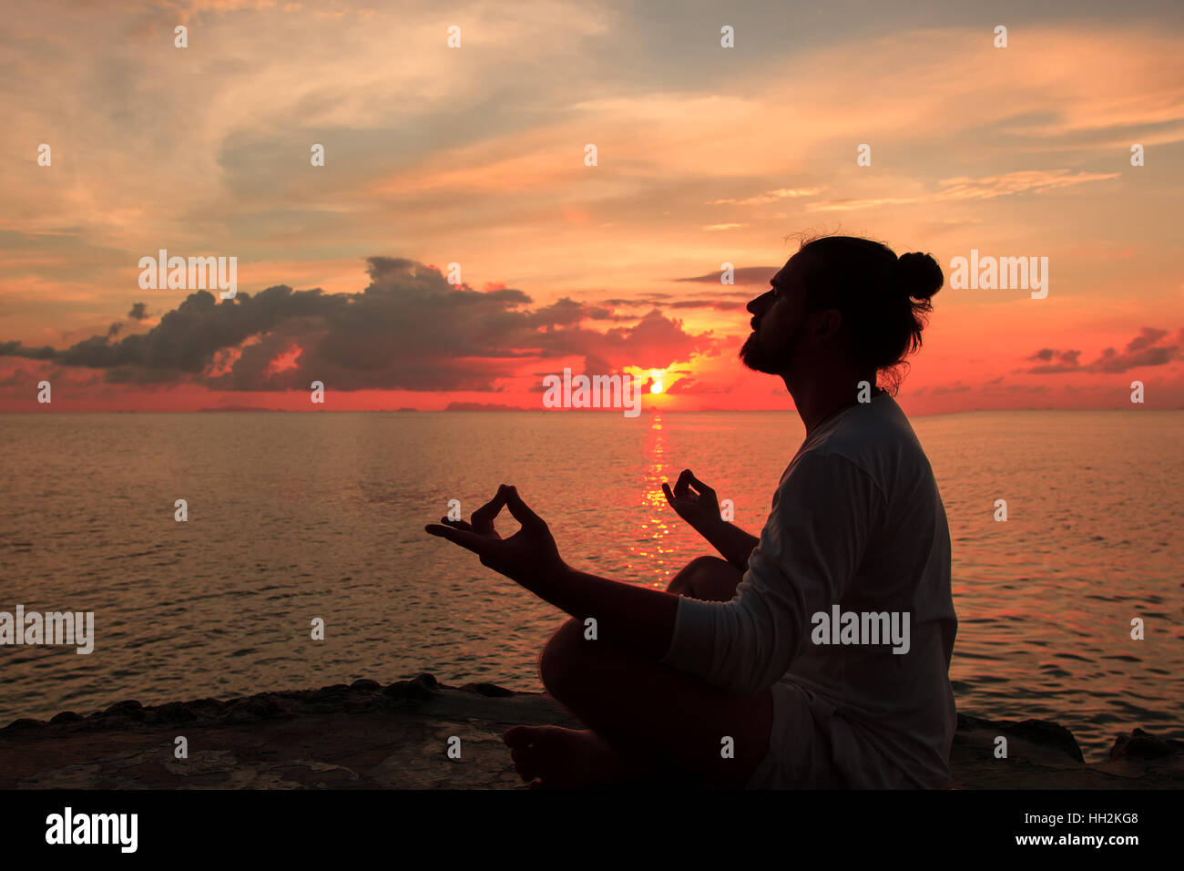 Yoga scene man silhouette in sunset background Stock Photo - Alamy