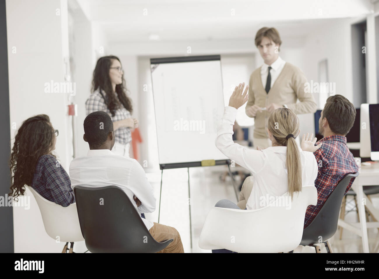 Businessman giving a presentation to his colleagues at work standing in ...