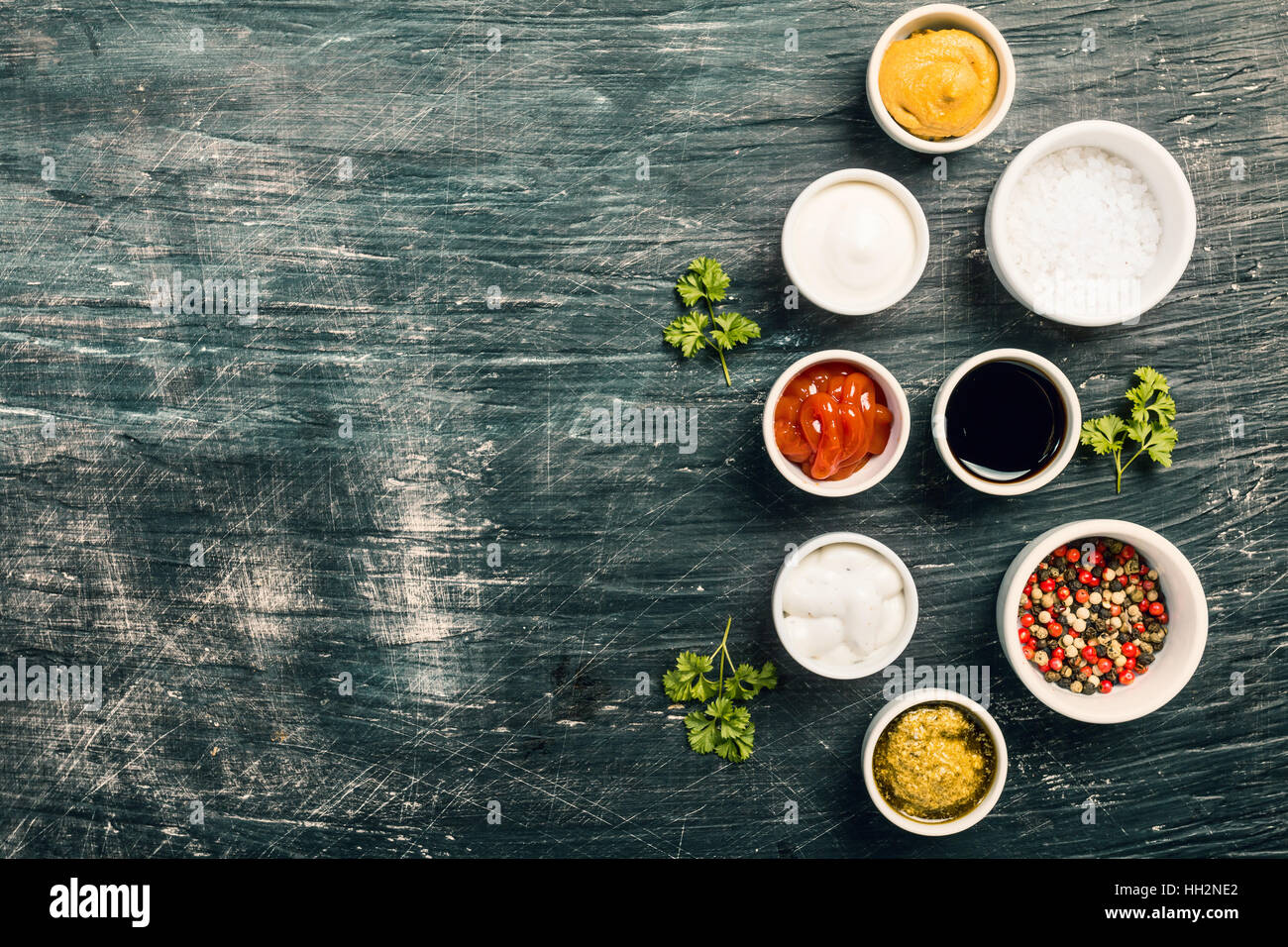 bowls of various dip sauces on black background, top view with copy ...