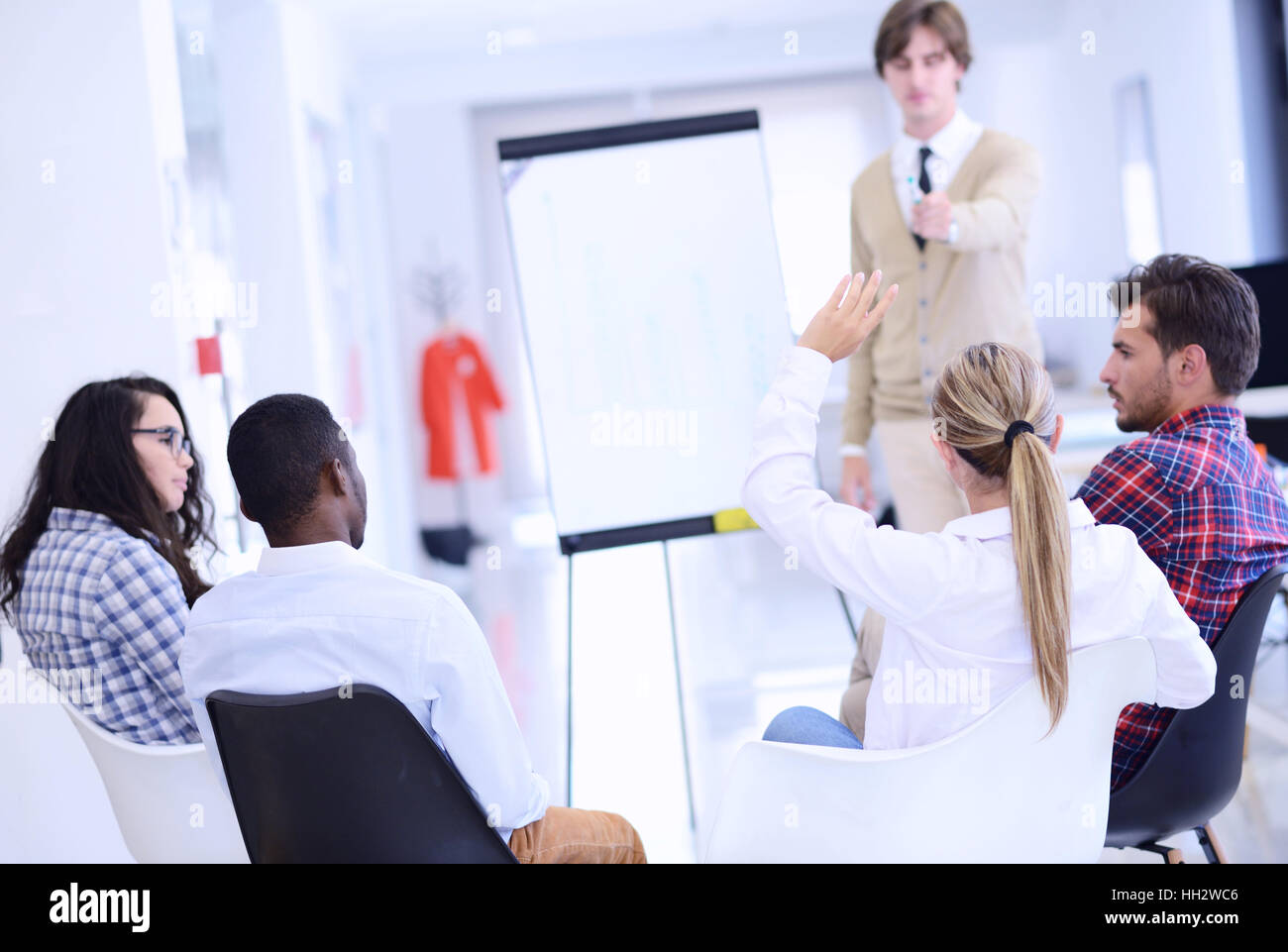 Businessman giving a presentation to his colleagues at work standing in ...