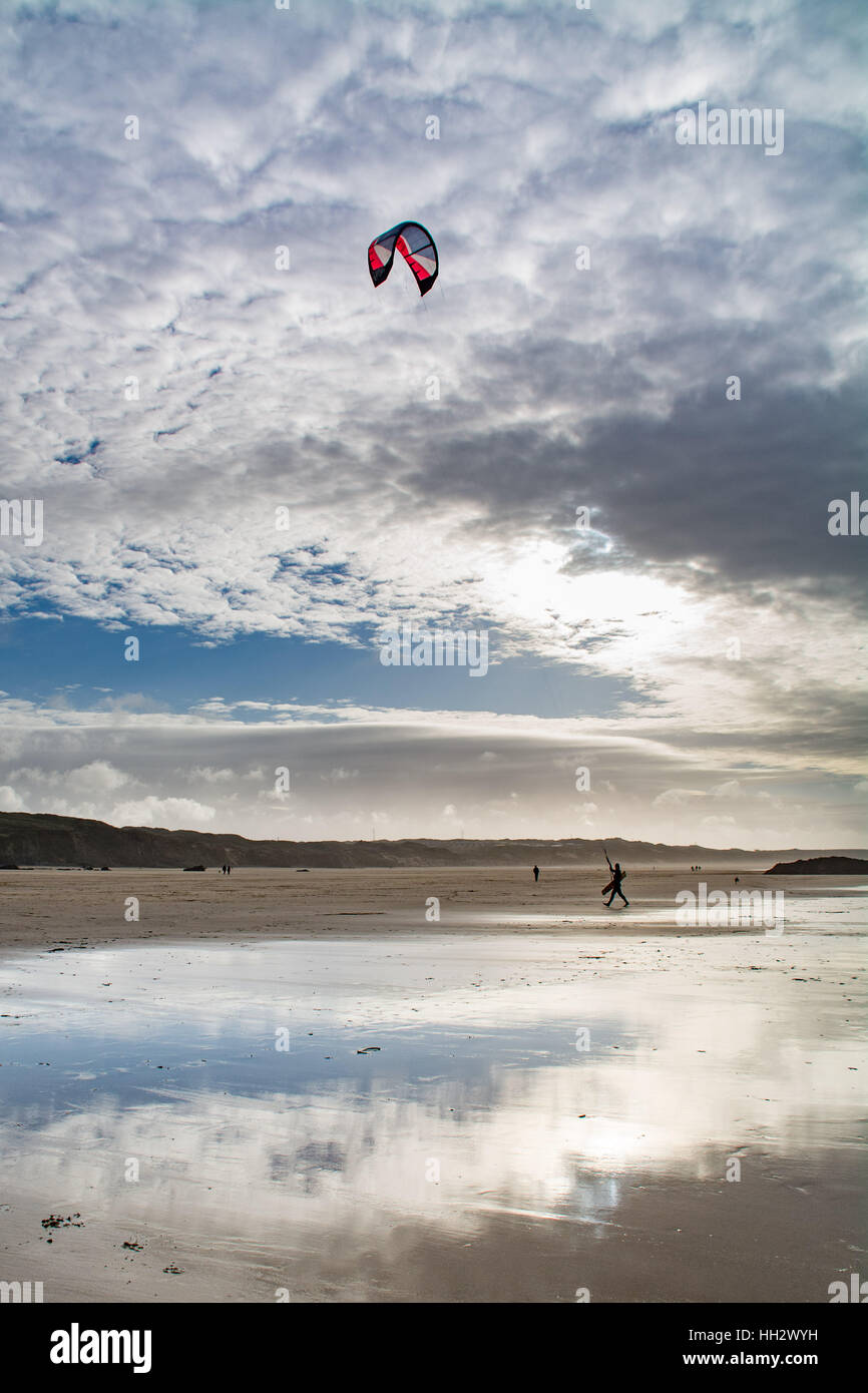 kite surfer walking across beach with kite against white clouds Stock ...