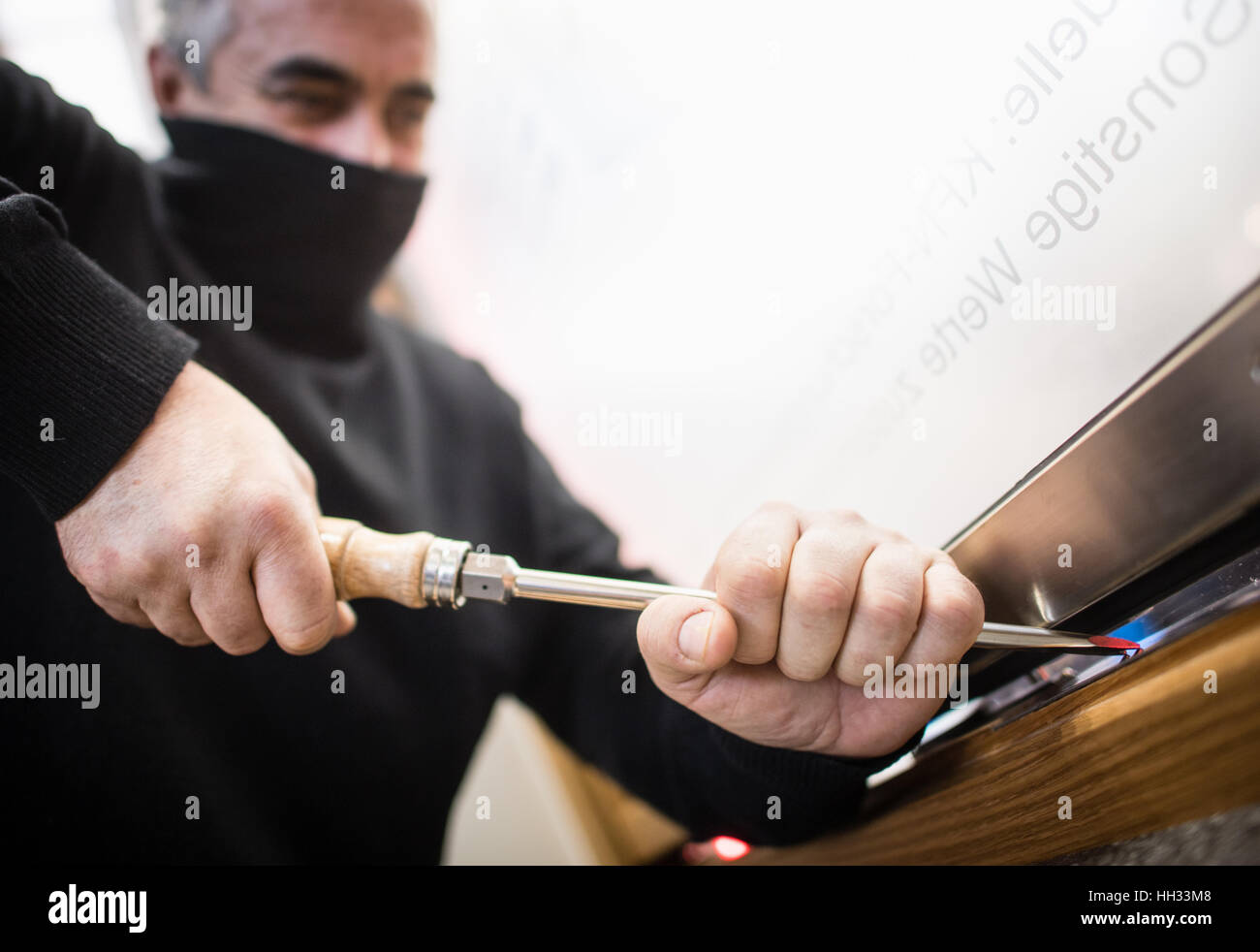 Munich, Germany. 16th Jan, 2017. A man tries to prise open a window ...