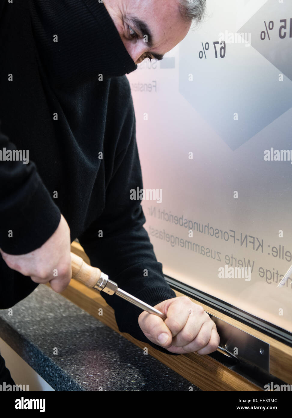 Munich, Germany. 16th Jan, 2017. A man tries to prise open a window ...