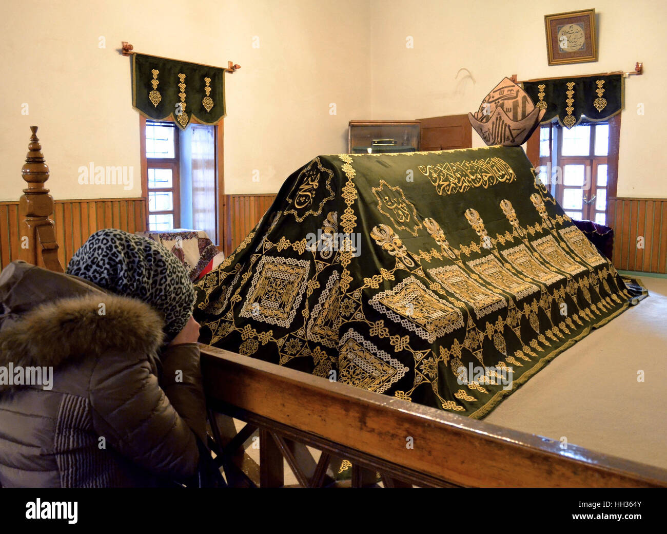 A pilgrim stands in front of the coffin of the Islamic mystic and poet ...
