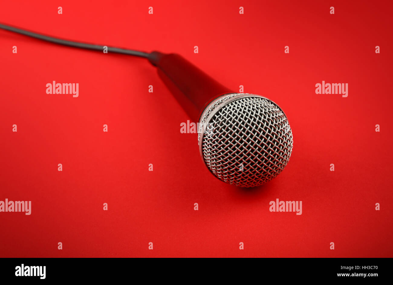 Vintage old retro vocal metal microphone side view close up over red ...