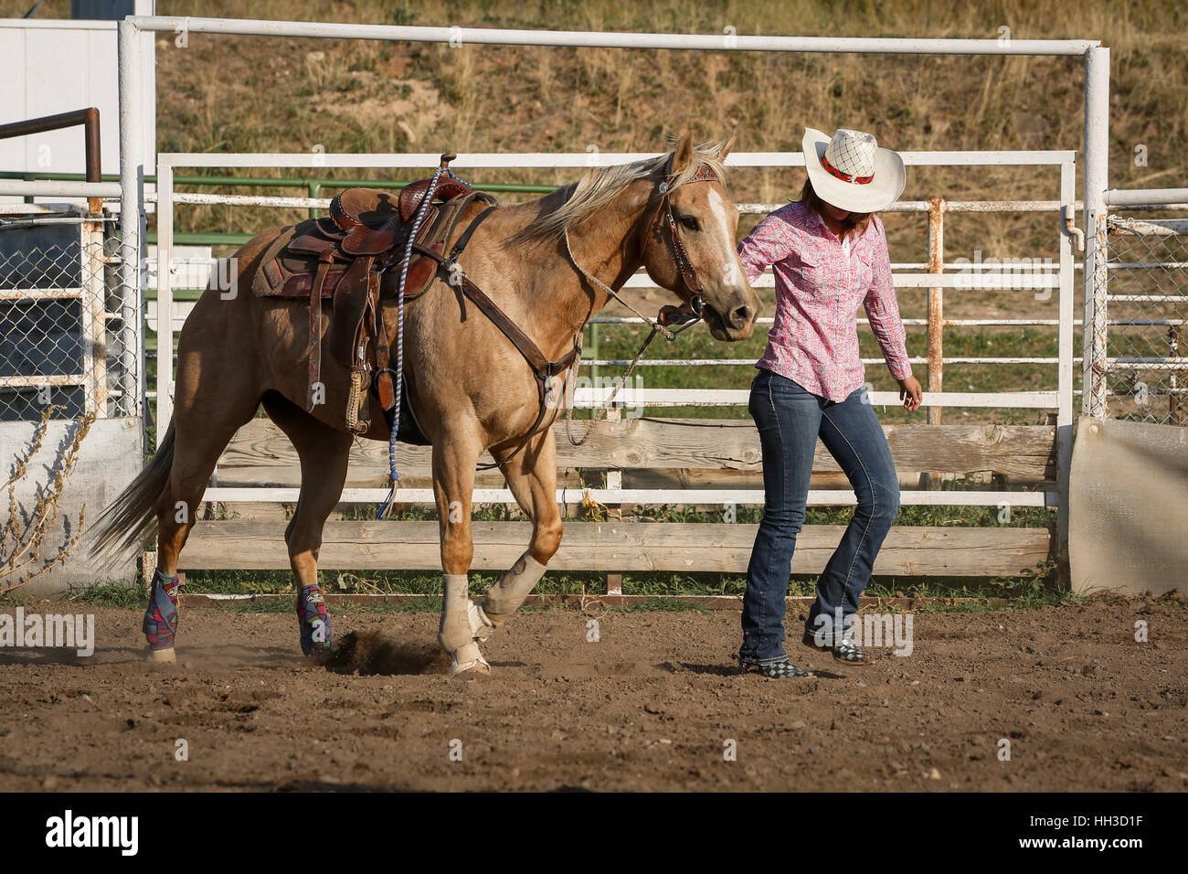 Teenage girl leading her horse through a rodeo arena at a youth rodeo ...