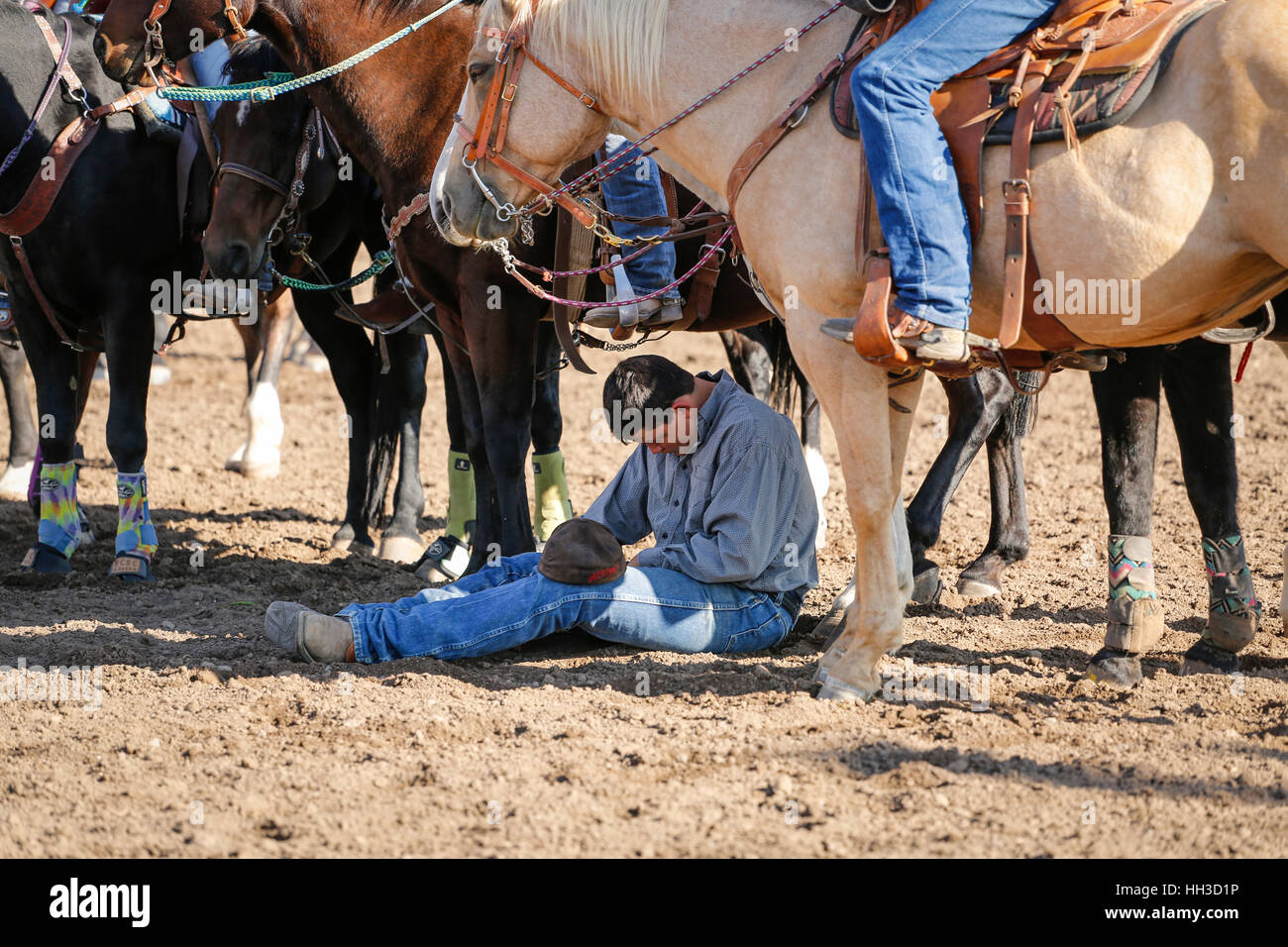 Young cowboy bowing his head in prayer before the start of a youth ...