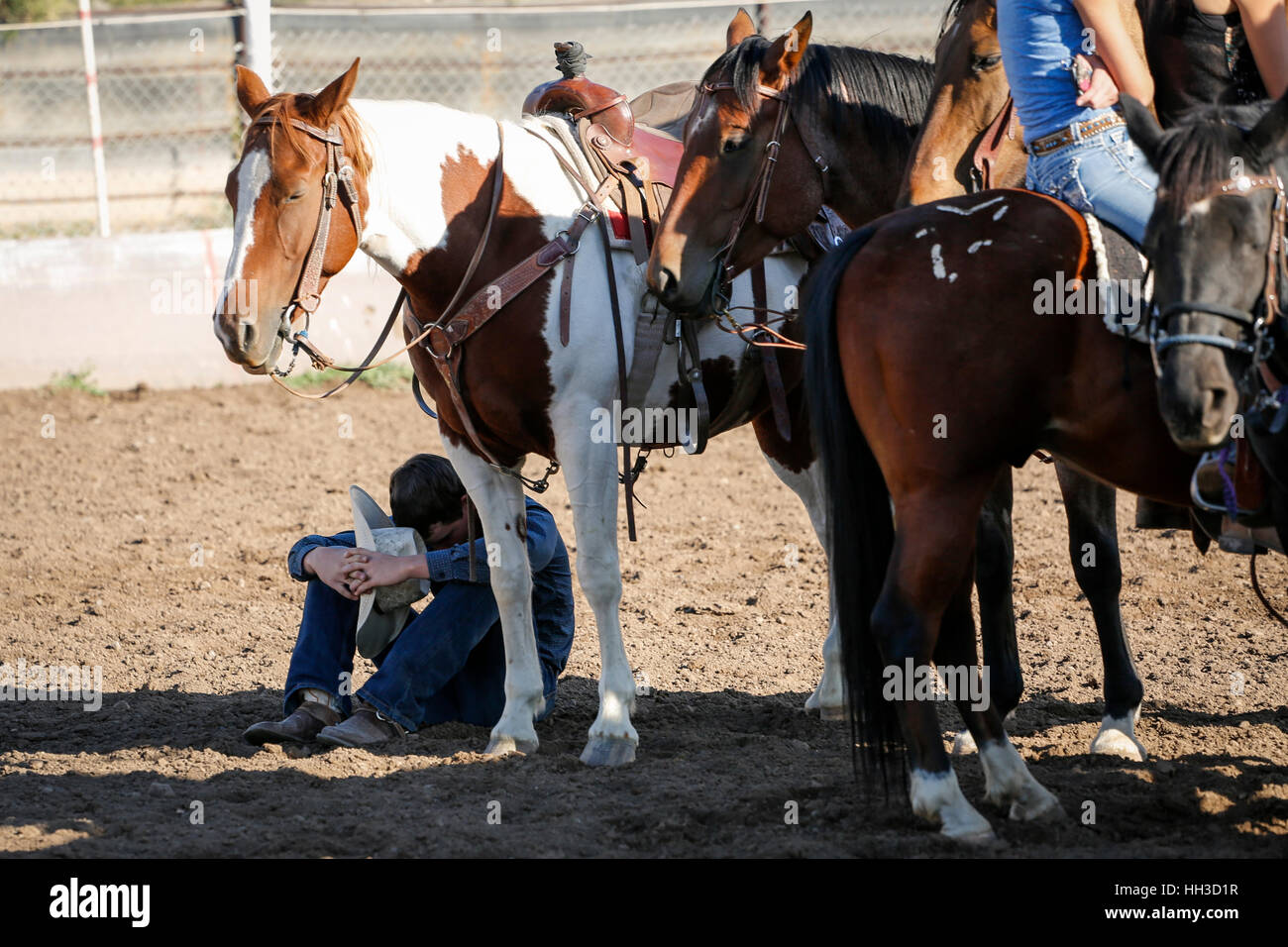 Young cowboy bowing his head in prayer before the start of a youth ...