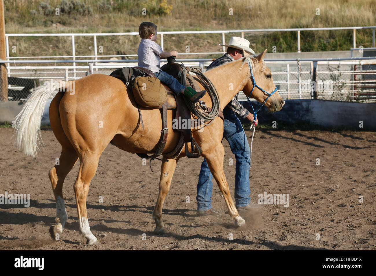 Young child being led on a horse by his father during a youth rodeo ...