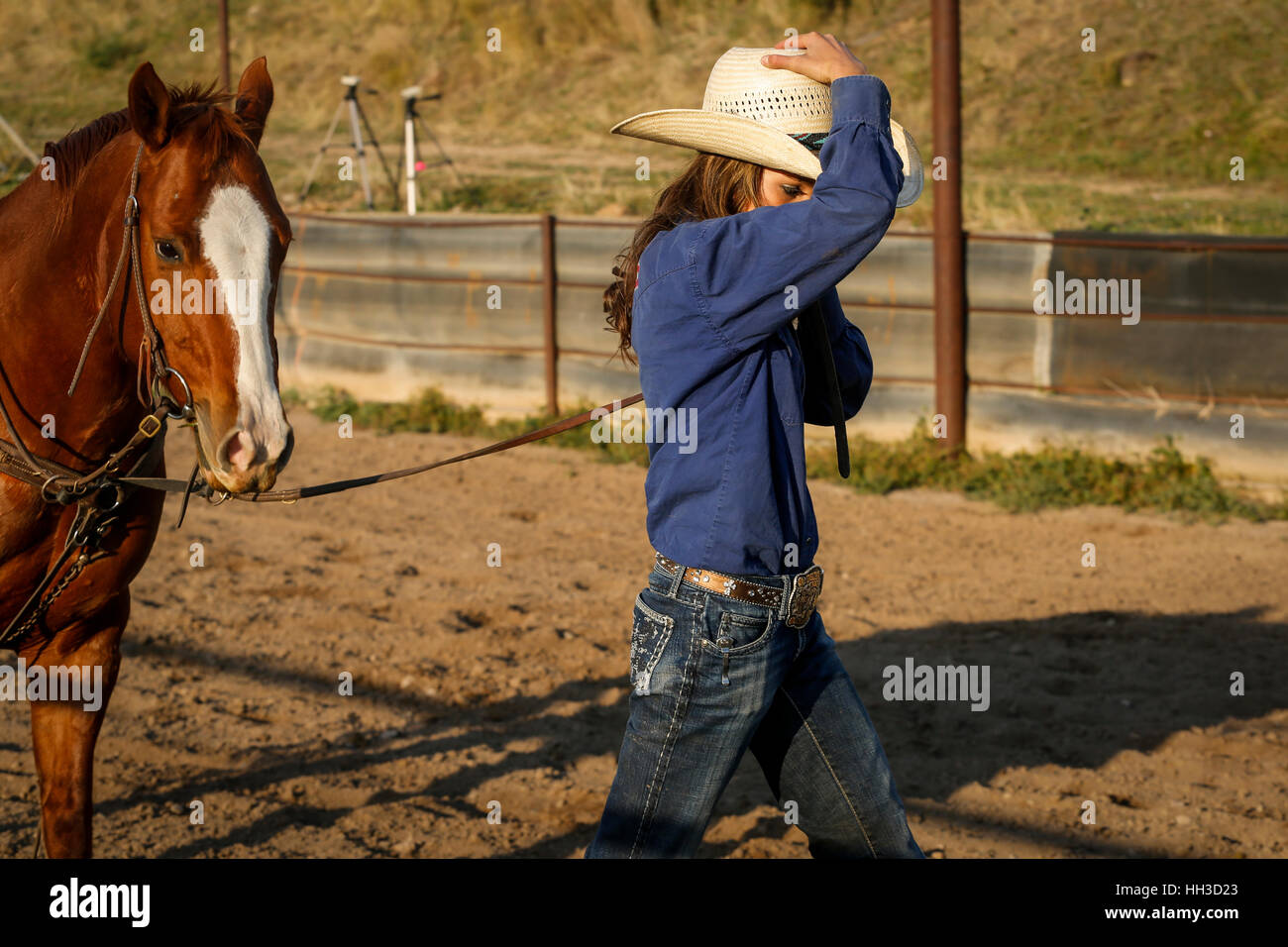Teenage girl leading her horse through a rodeo arena at a youth rodeo ...