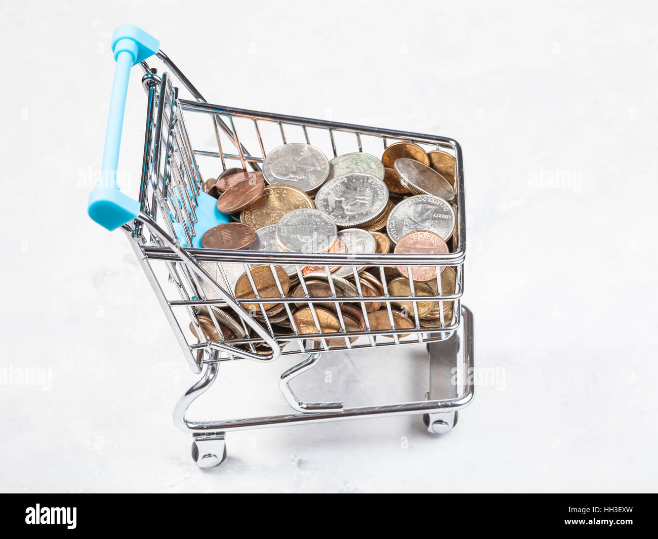 shopping cart with US coins on concrete board Stock Photo - Alamy