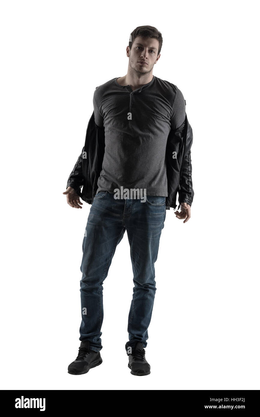 Back lit silhouette of casual man taking off jacket looking at camera ...