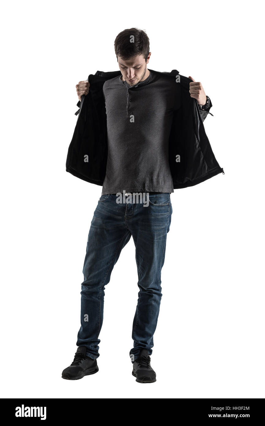 Silhouette back lit casual man taking off jacket looking down. Full ...
