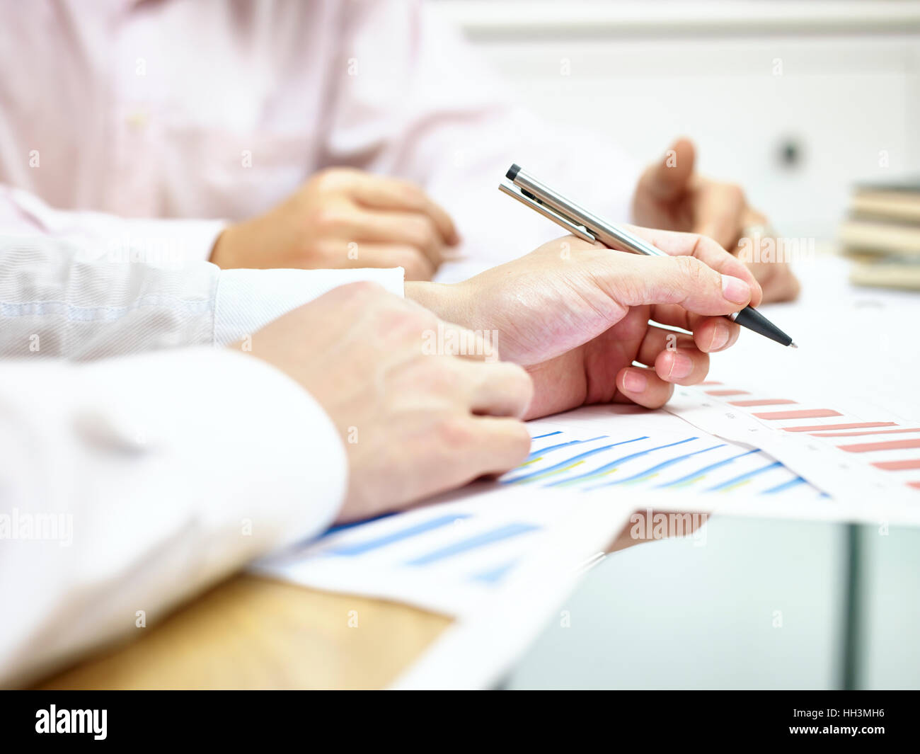 two business executives sitting at desk discussing sales performance ...