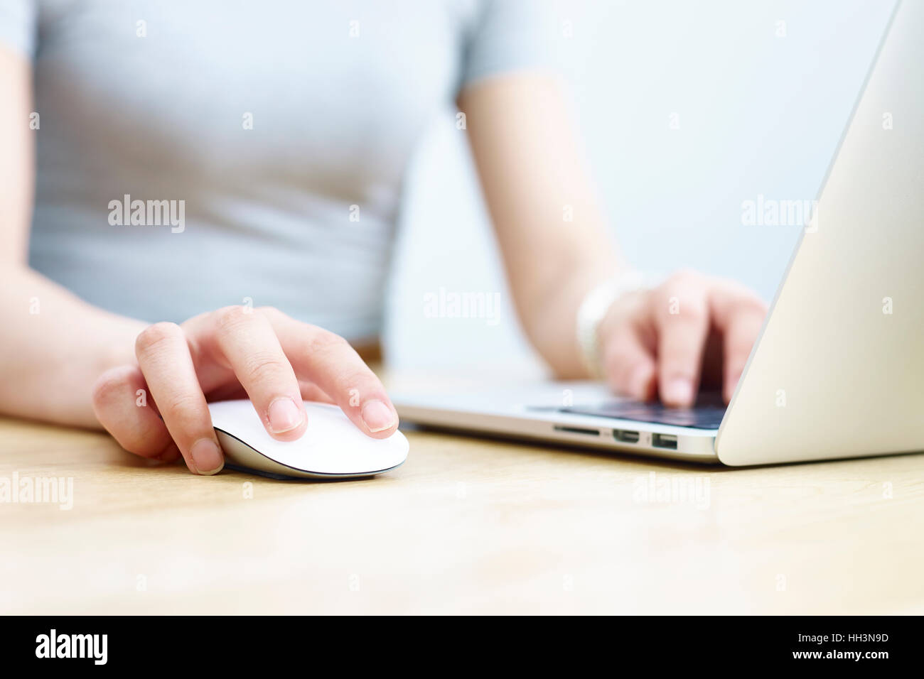 hand of a young woman clicking a mouse working on laptop computer in ...