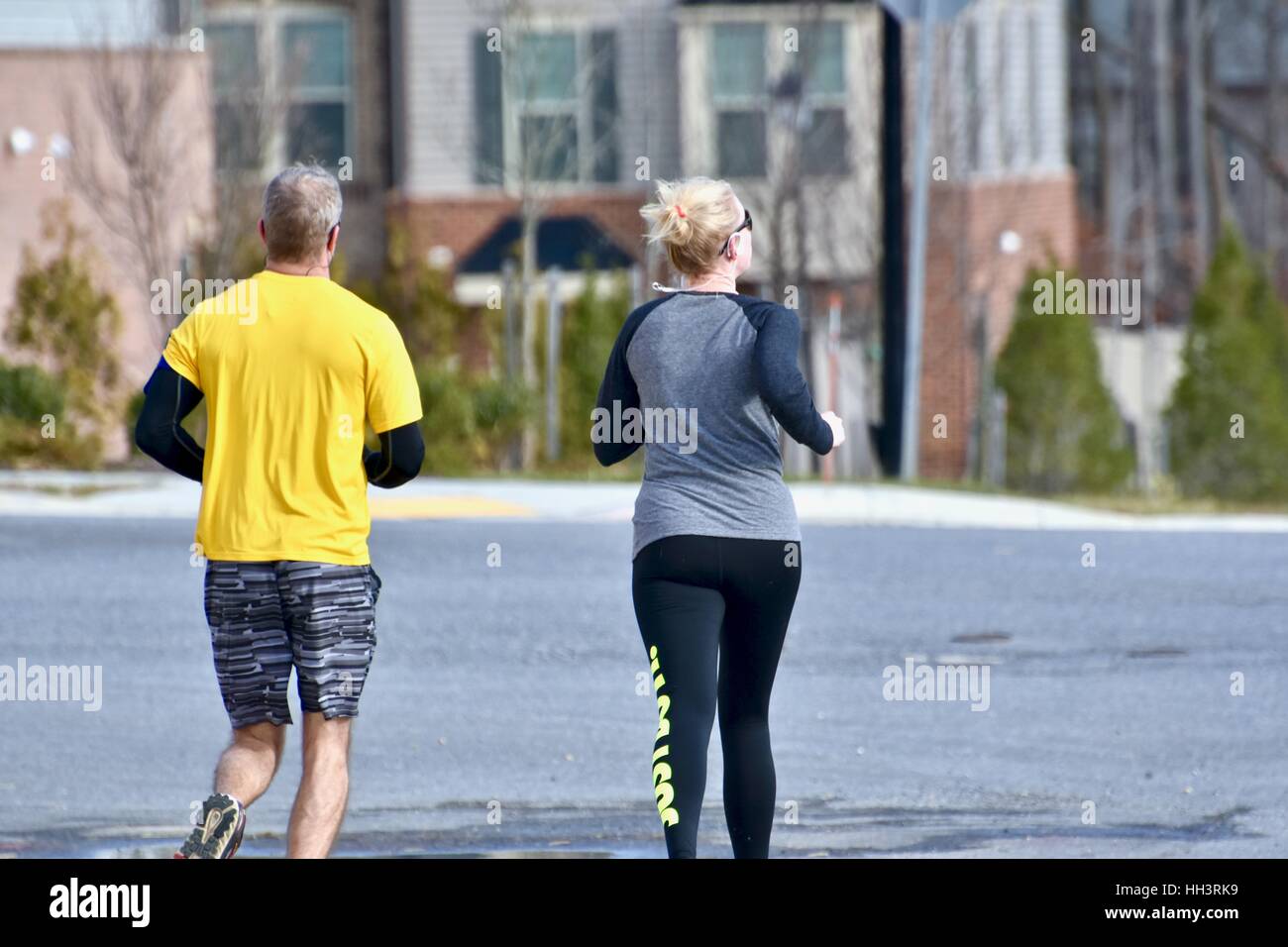 A married couple going for a run through the neighborhood Stock Photo ...