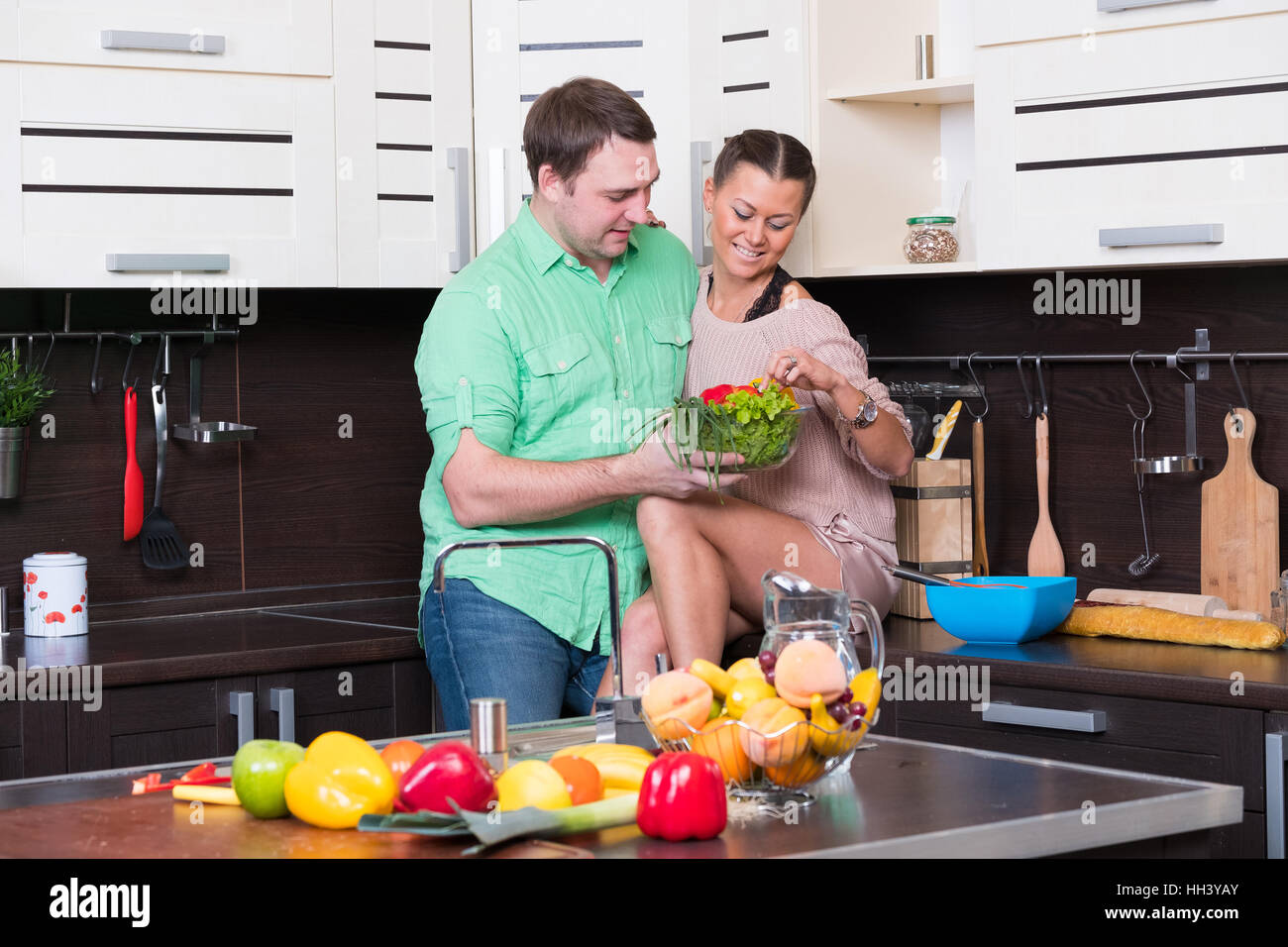 Young couple having fun in the kitchen Stock Photo - Alamy