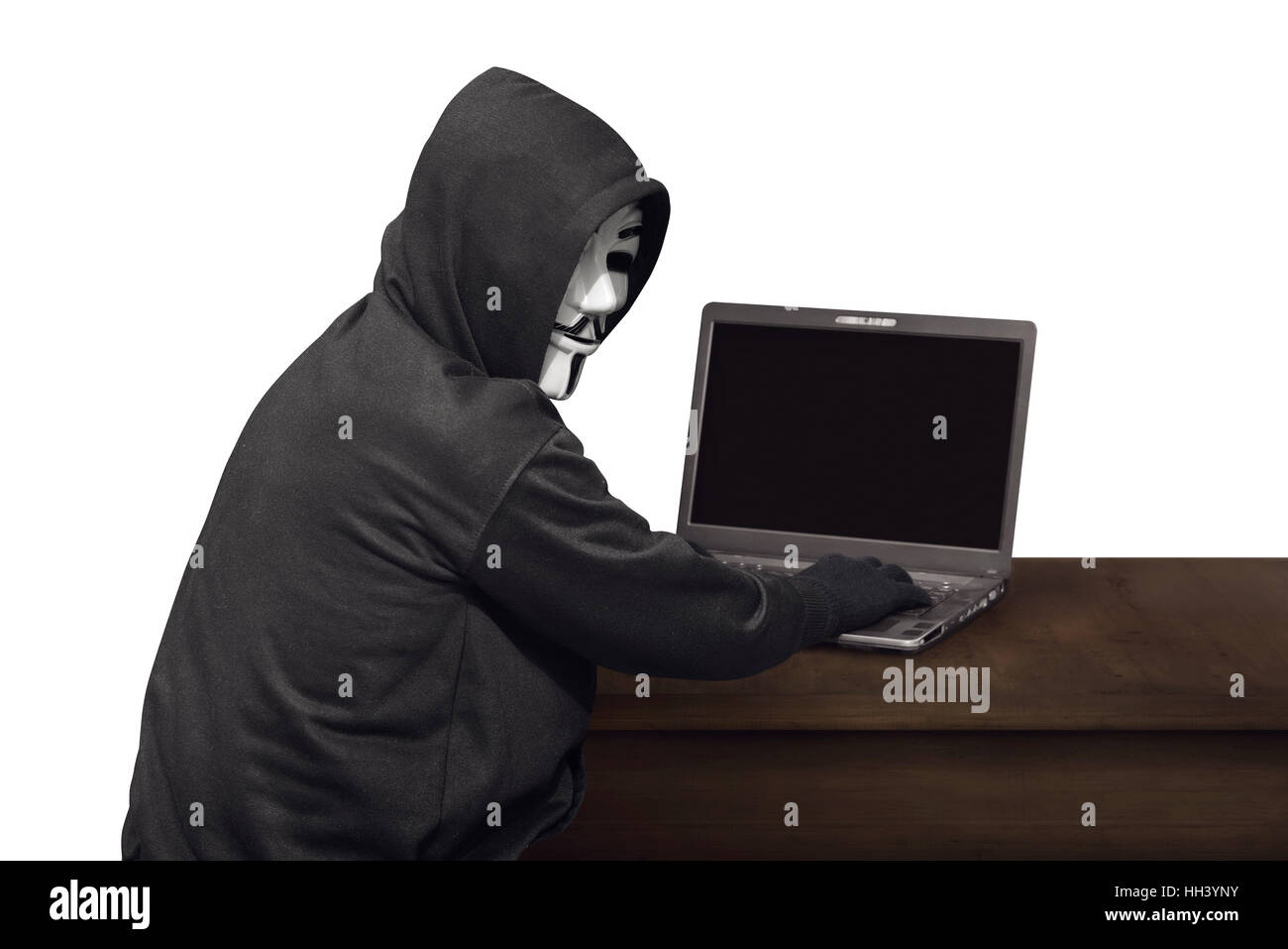 Portrait of hacker man with mask looking back while typing laptop on ...