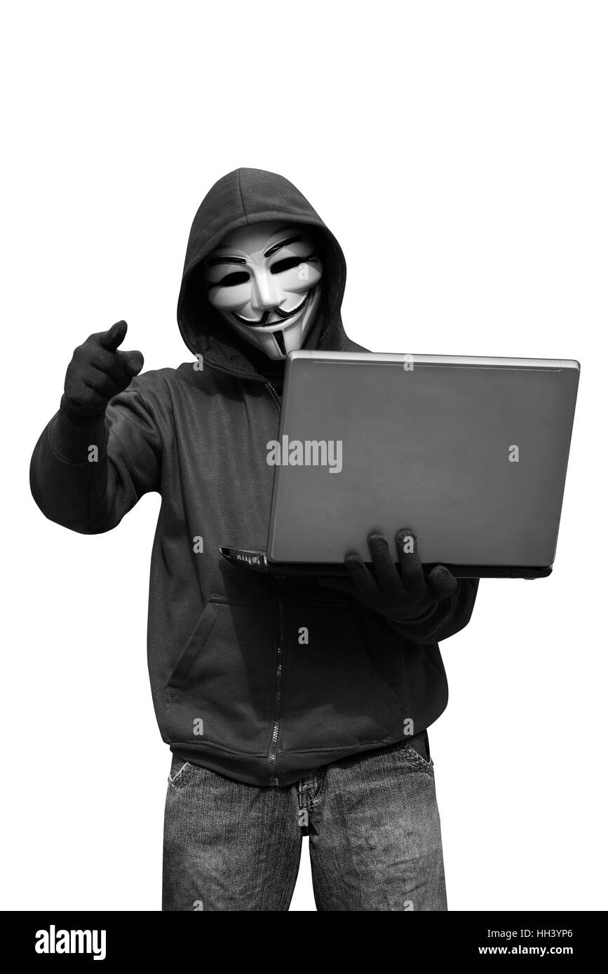 Hooded hacker with mask holding laptop while appoint isolated against ...