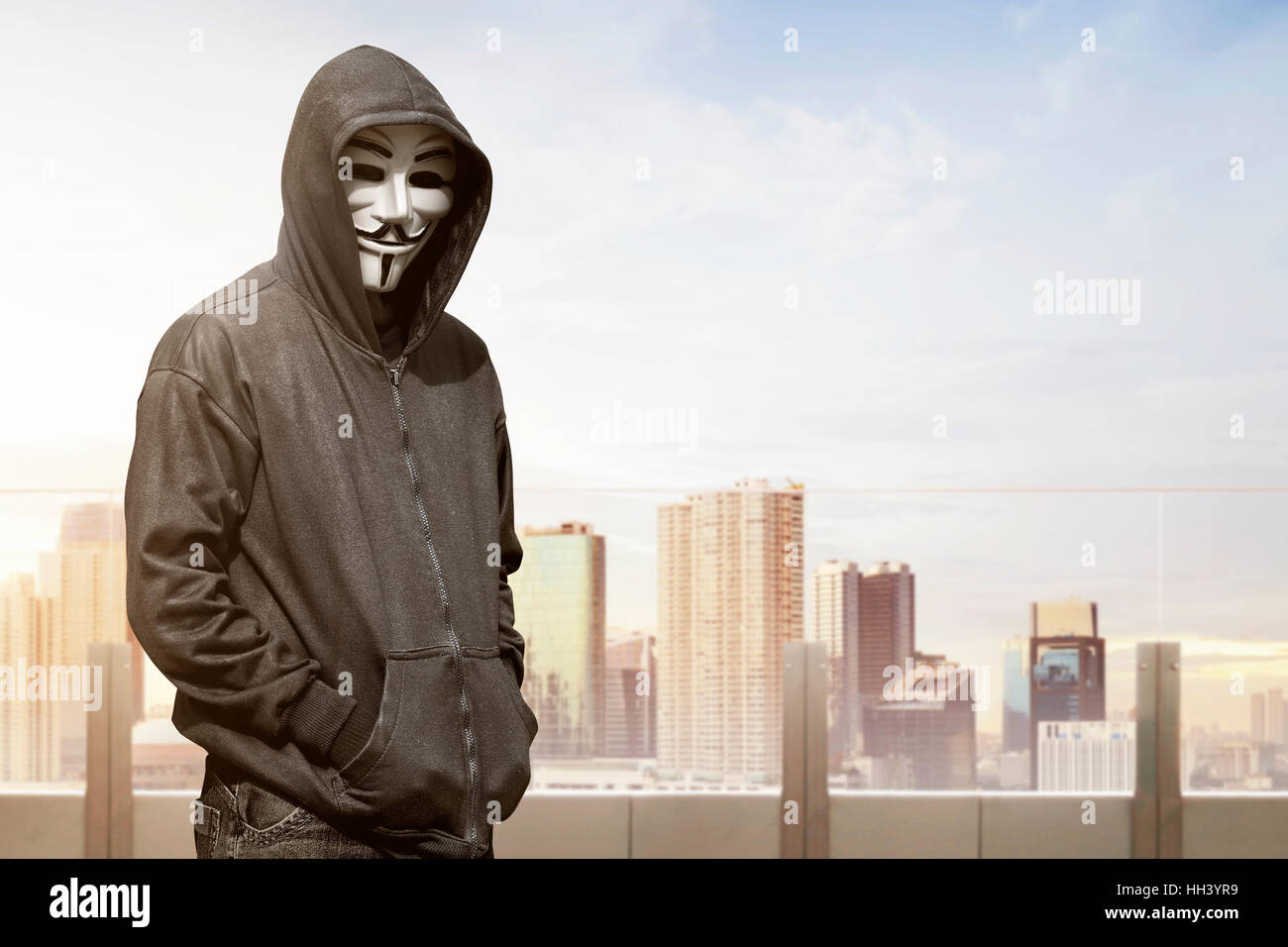 Man with vendetta mask standing against cityscape background Stock ...