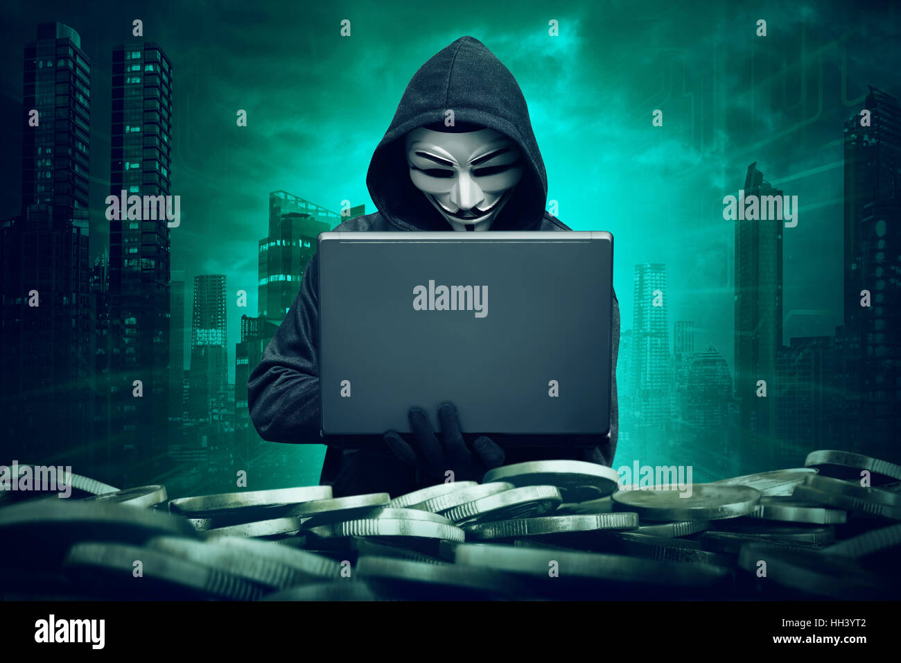 Hooded hacker with mask using laptop to hacking bank system security on ...