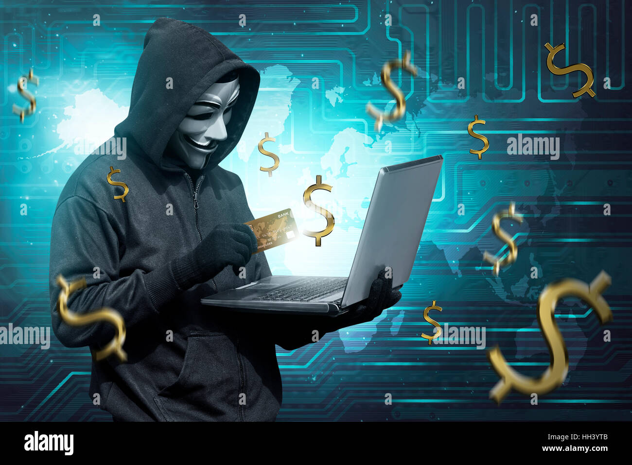 Hacker man with mask holding credit card with laptop on his hand on ...