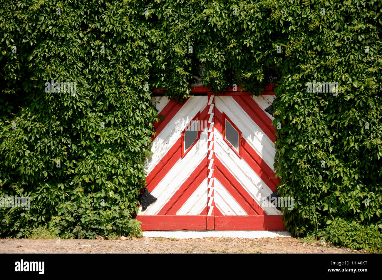 Two-winged wooden gate with red white stripes in a placid wall Stock ...