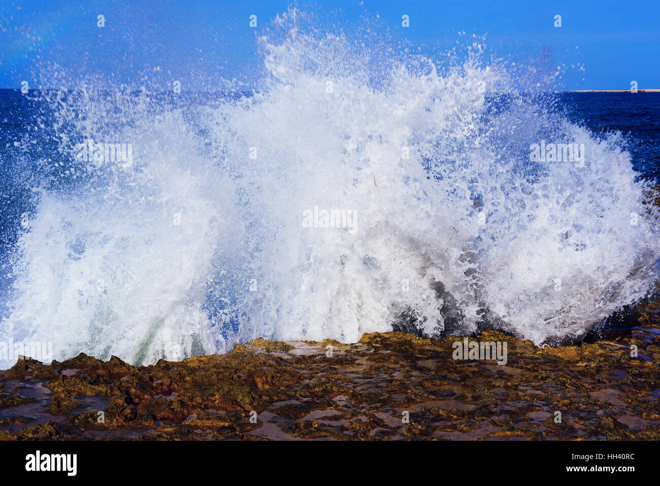 Sea splashing on rocks Stock Photo - Alamy