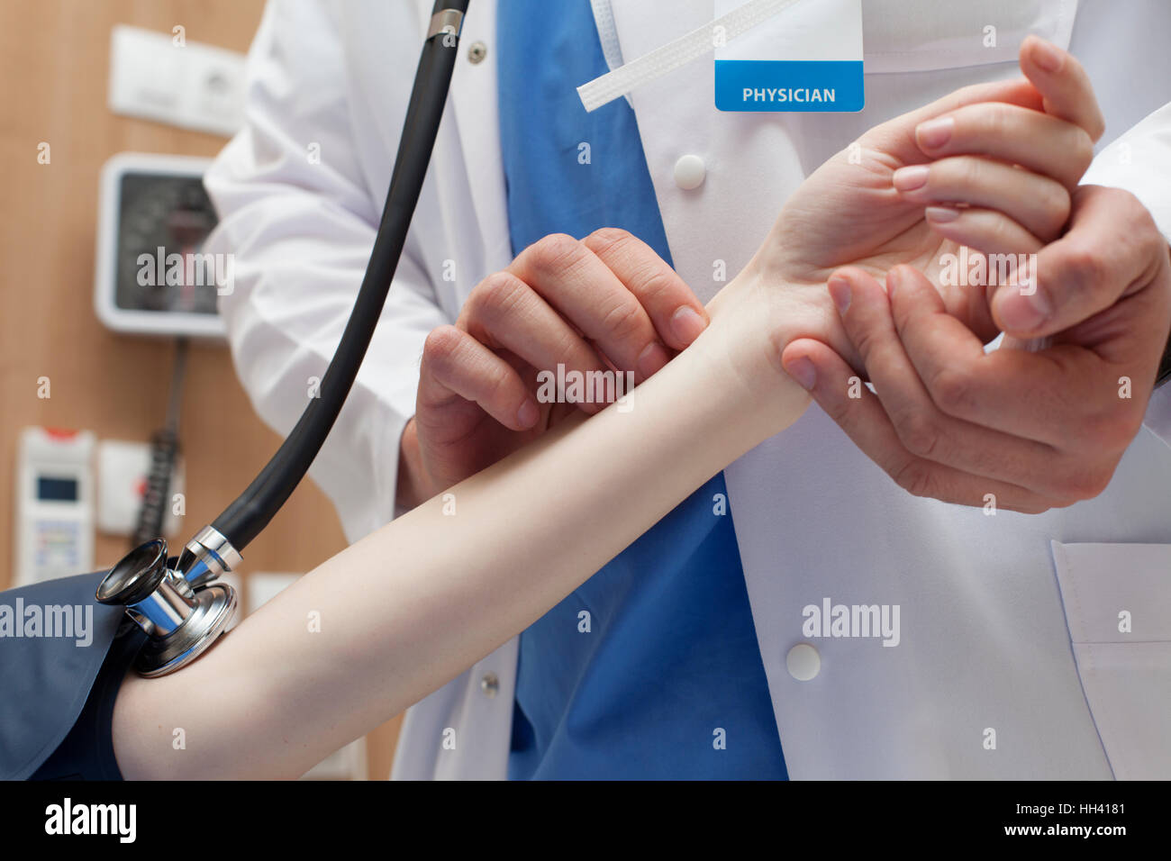Close-up of a doctor hands measuring the pulse of a patient in hospital ...