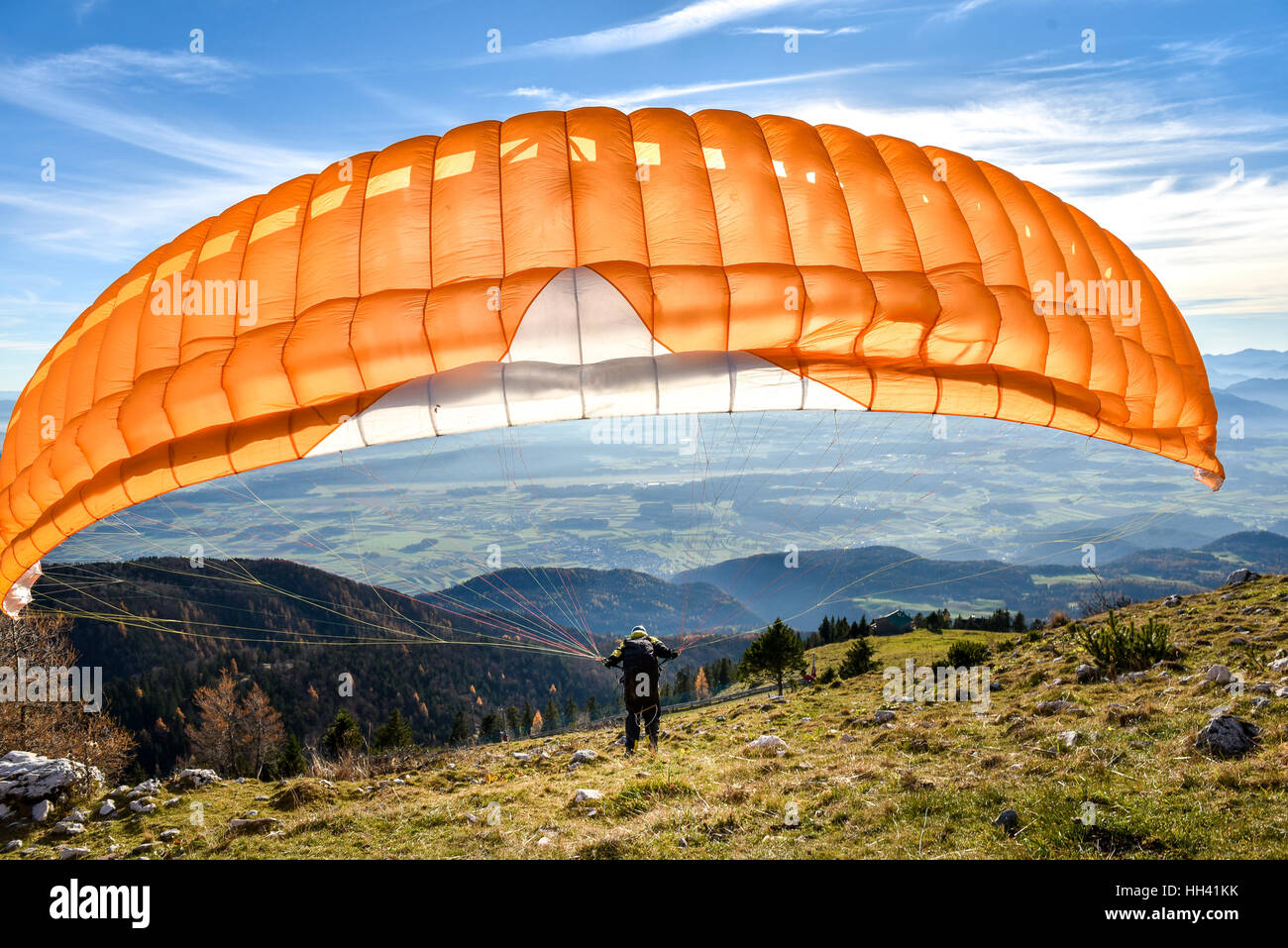 Paraglider is starting. Parachute is filling with air in the mountains ...