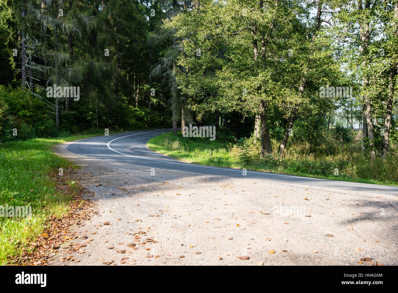 Winding country Road with clouds above and dry tarmac Stock Photo - Alamy