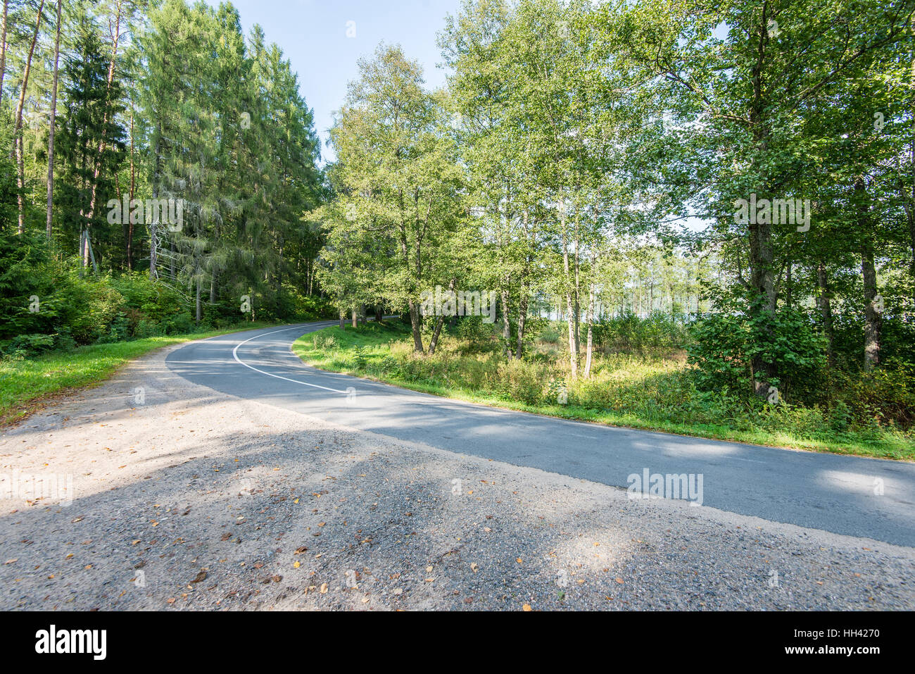 Winding country Road with clouds above and dry tarmac Stock Photo - Alamy