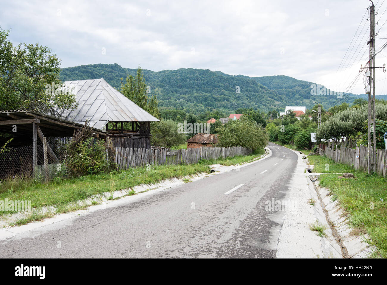 Winding country Road with clouds above and dry tarmac Stock Photo - Alamy