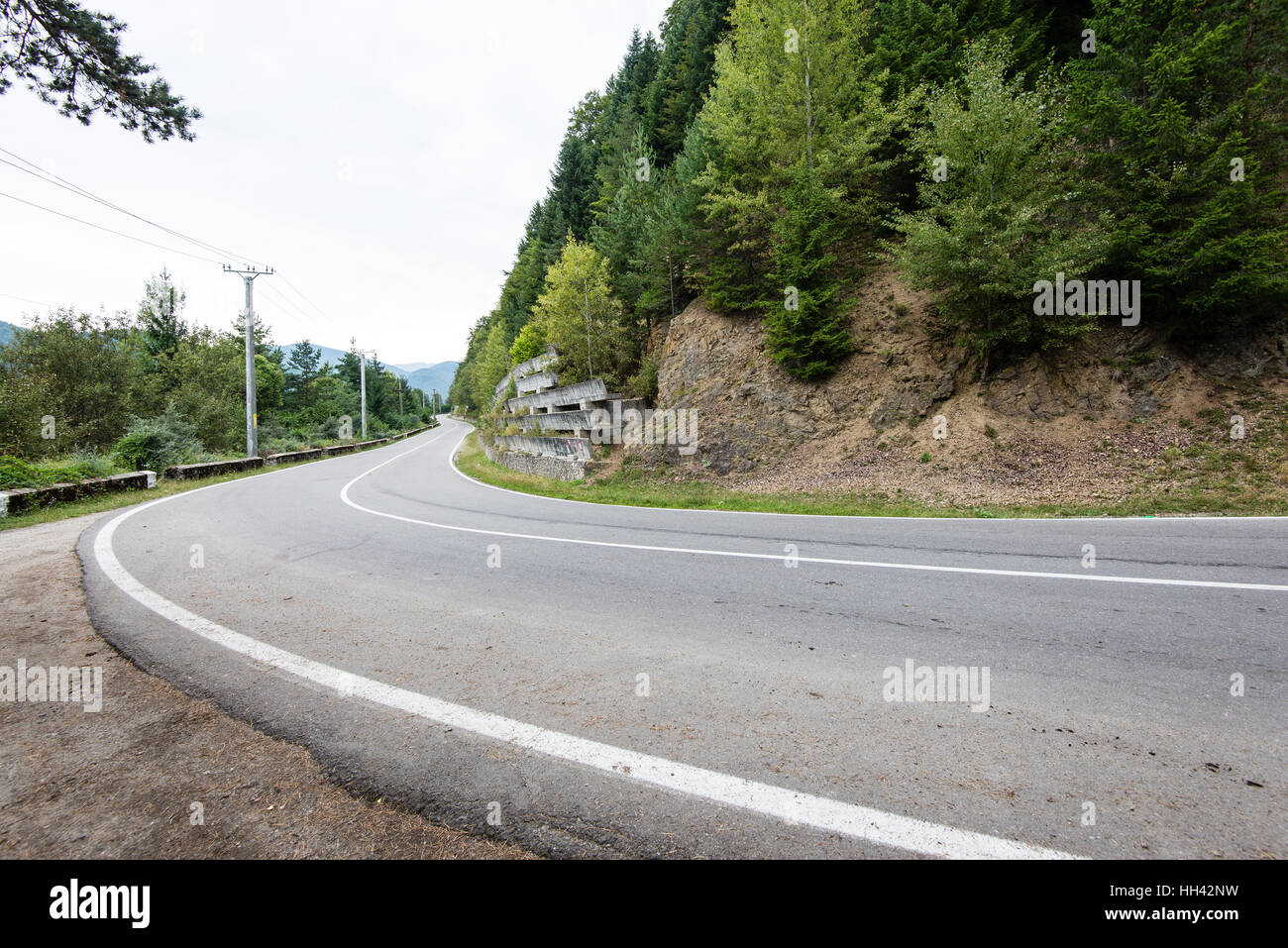 Winding country Road with clouds above and dry tarmac Stock Photo - Alamy