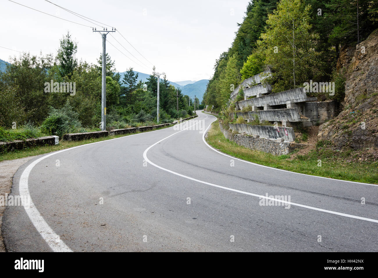 Winding country Road with clouds above and dry tarmac Stock Photo - Alamy