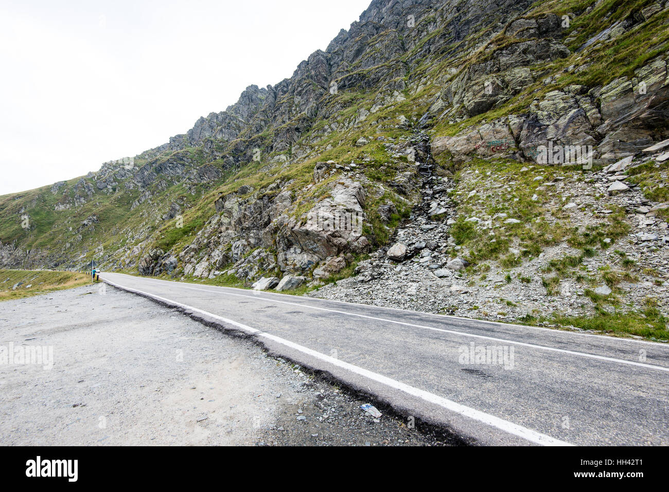 Winding country Road with clouds above and dry tarmac Stock Photo - Alamy