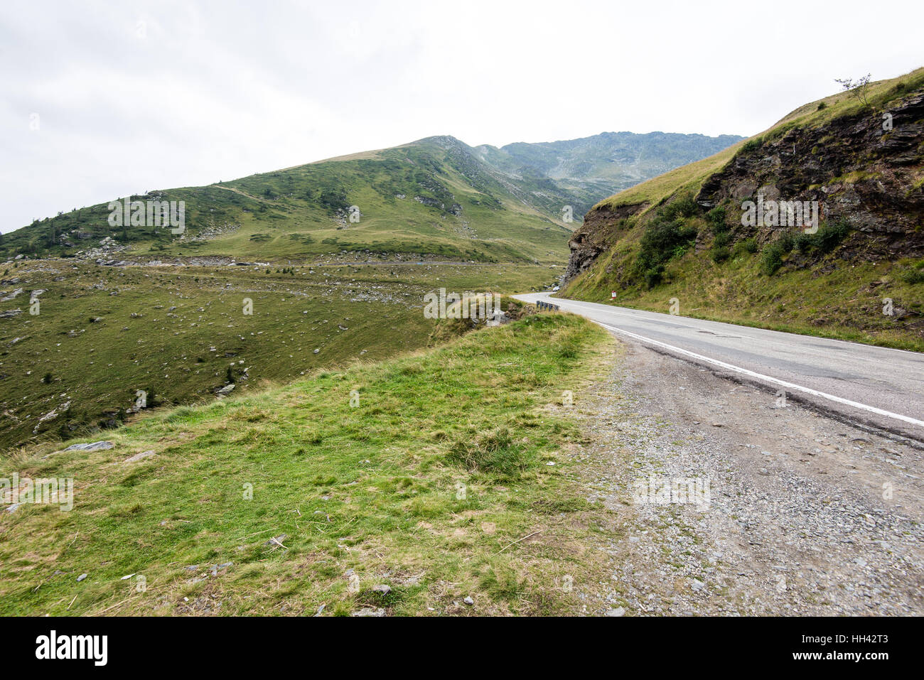 Winding country Road with clouds above and dry tarmac Stock Photo - Alamy
