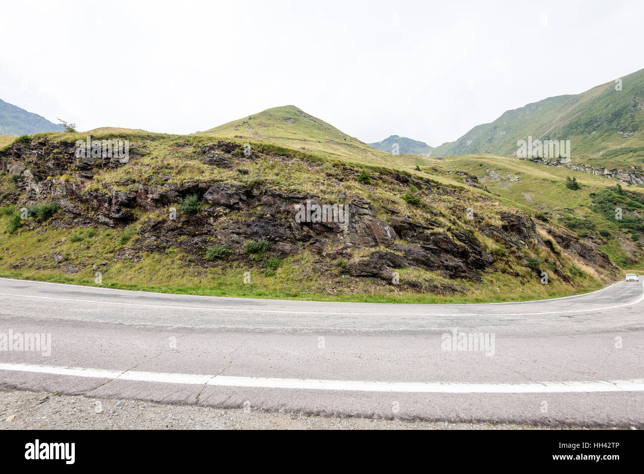 Winding country Road with clouds above and dry tarmac Stock Photo - Alamy