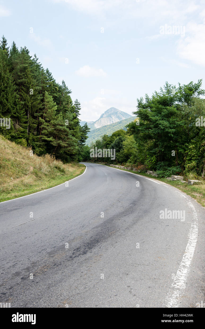 Winding country Road with clouds above and dry tarmac Stock Photo - Alamy