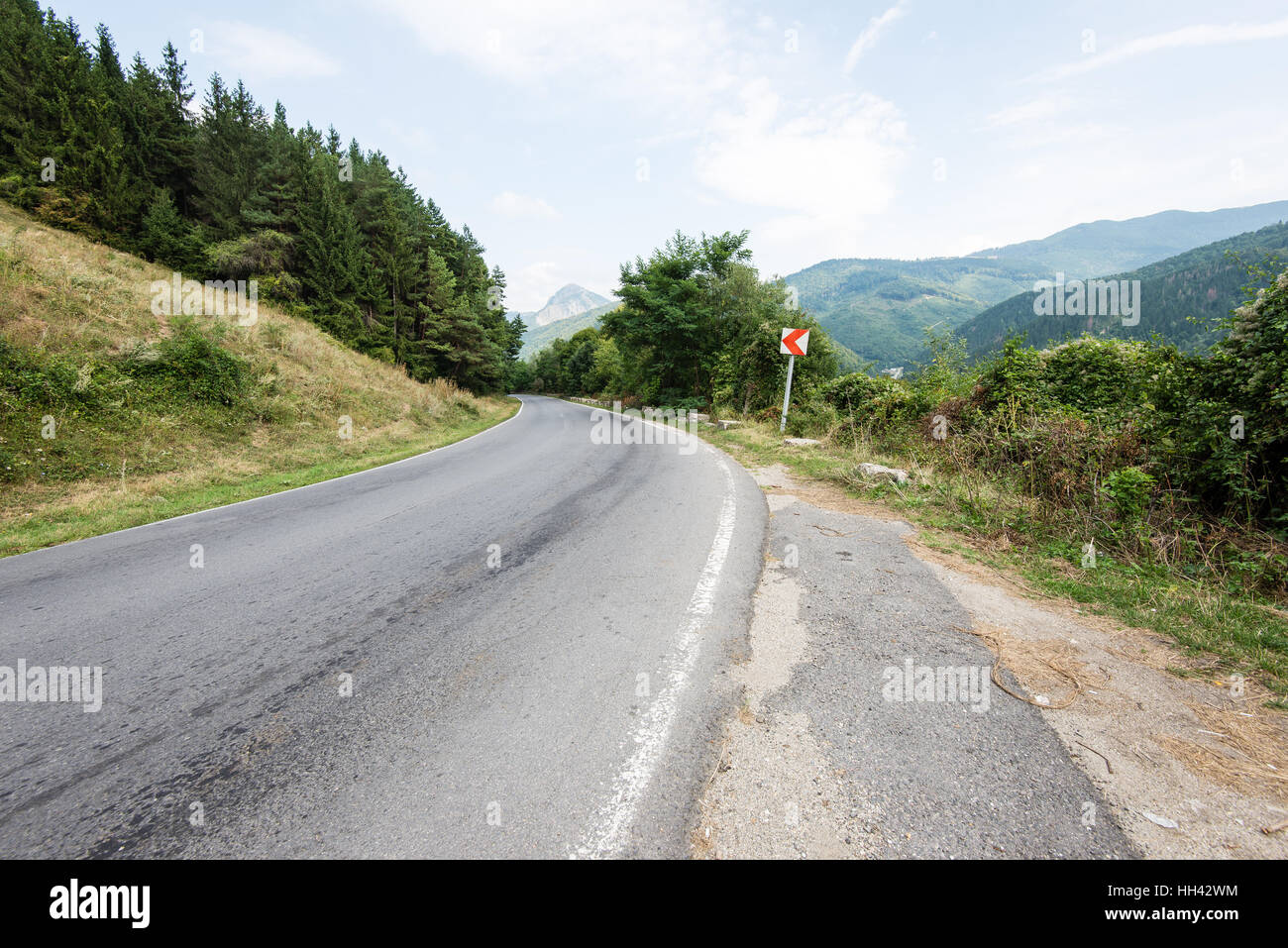 Winding country Road with clouds above and dry tarmac Stock Photo - Alamy