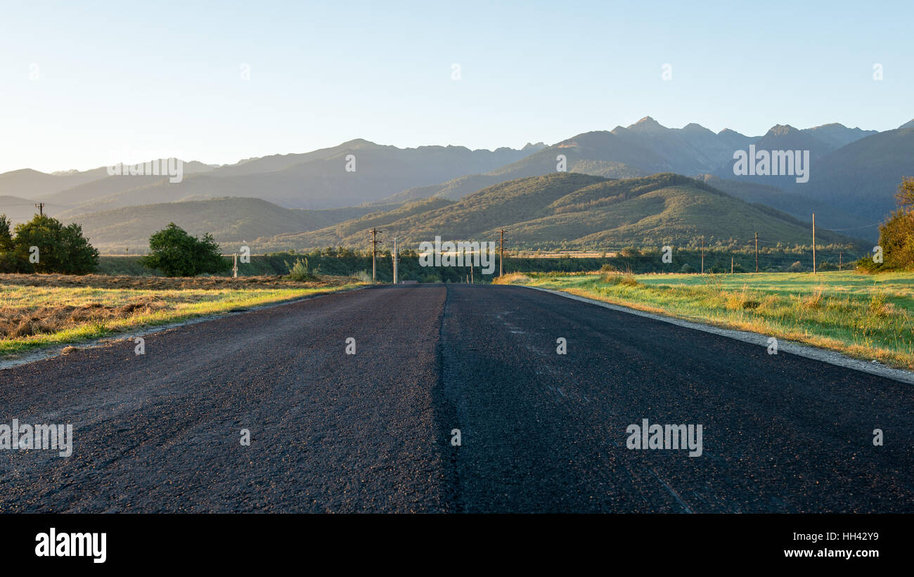 Winding country Road with clouds above and dry tarmac Stock Photo - Alamy