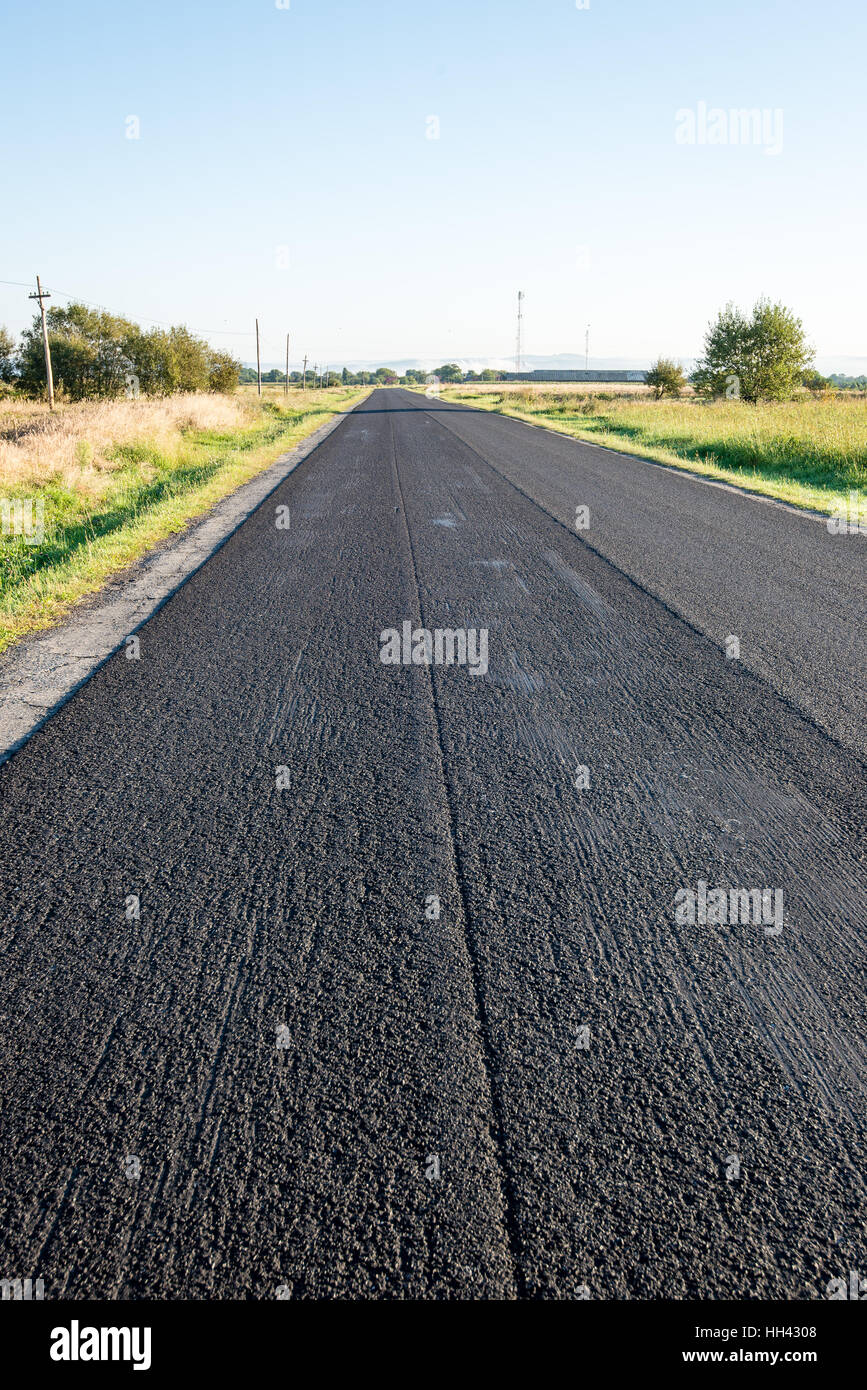 Winding country Road with clouds above and dry tarmac Stock Photo - Alamy