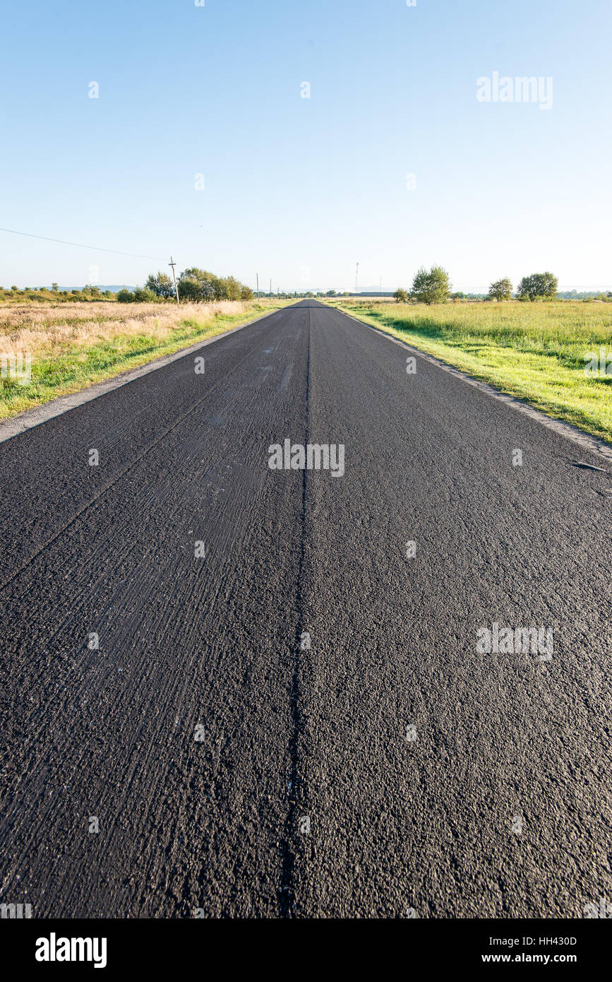 Winding country Road with clouds above and dry tarmac Stock Photo - Alamy