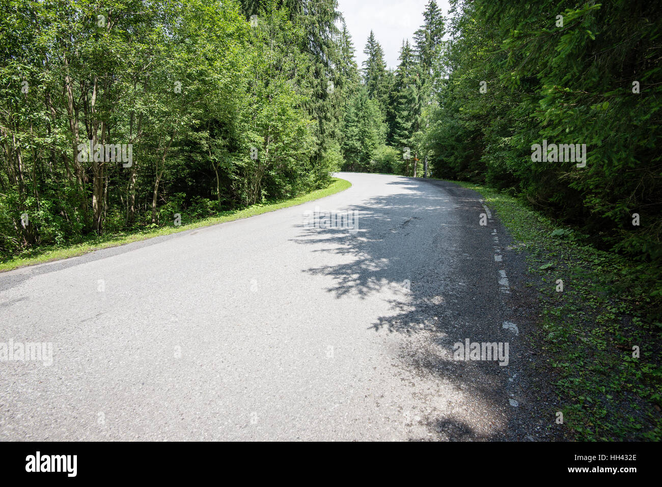 Winding country Road with clouds above and dry tarmac Stock Photo - Alamy